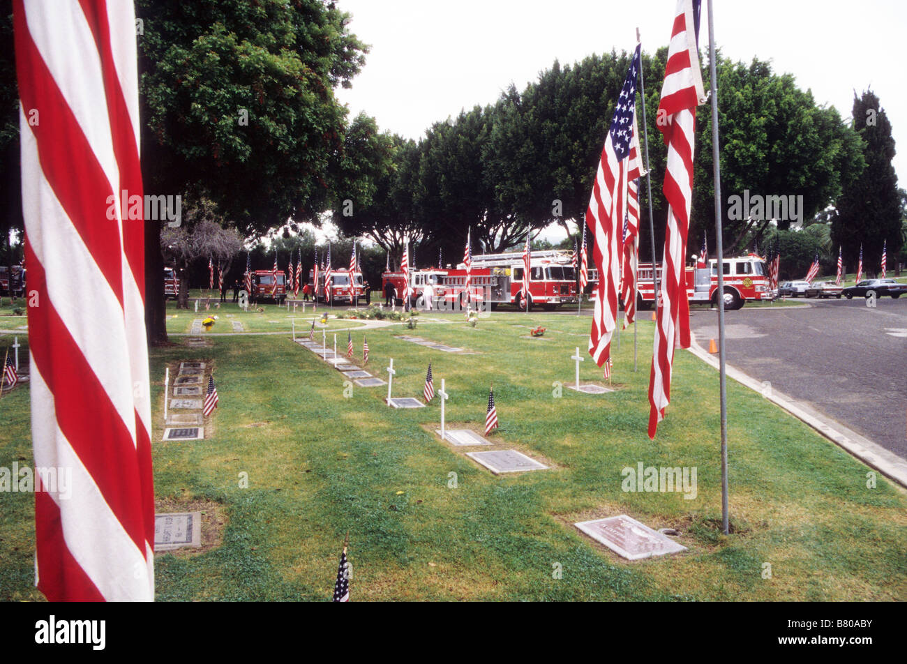 Fire trucks and firemen gather at cemetery decorated with American ...