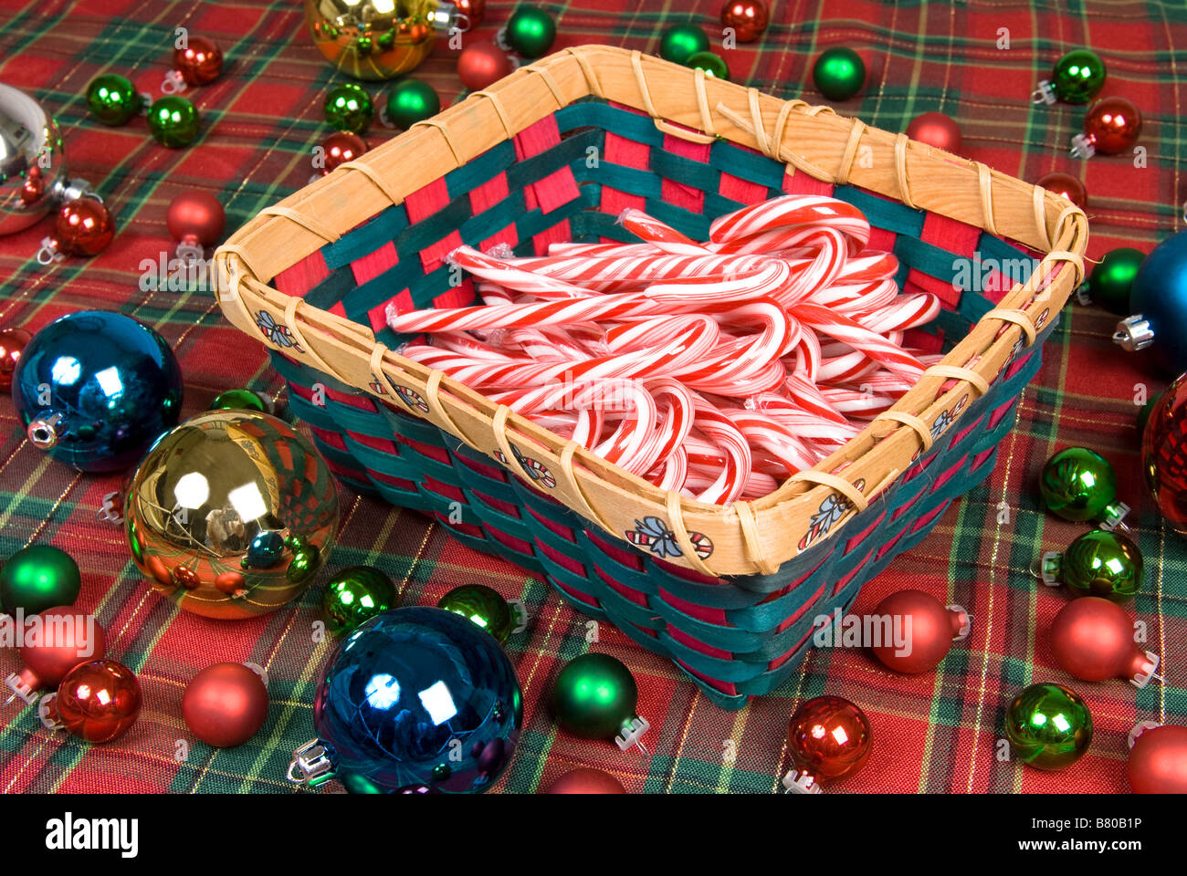 A basket of Christmas candy canes with a colorful holiday background ...