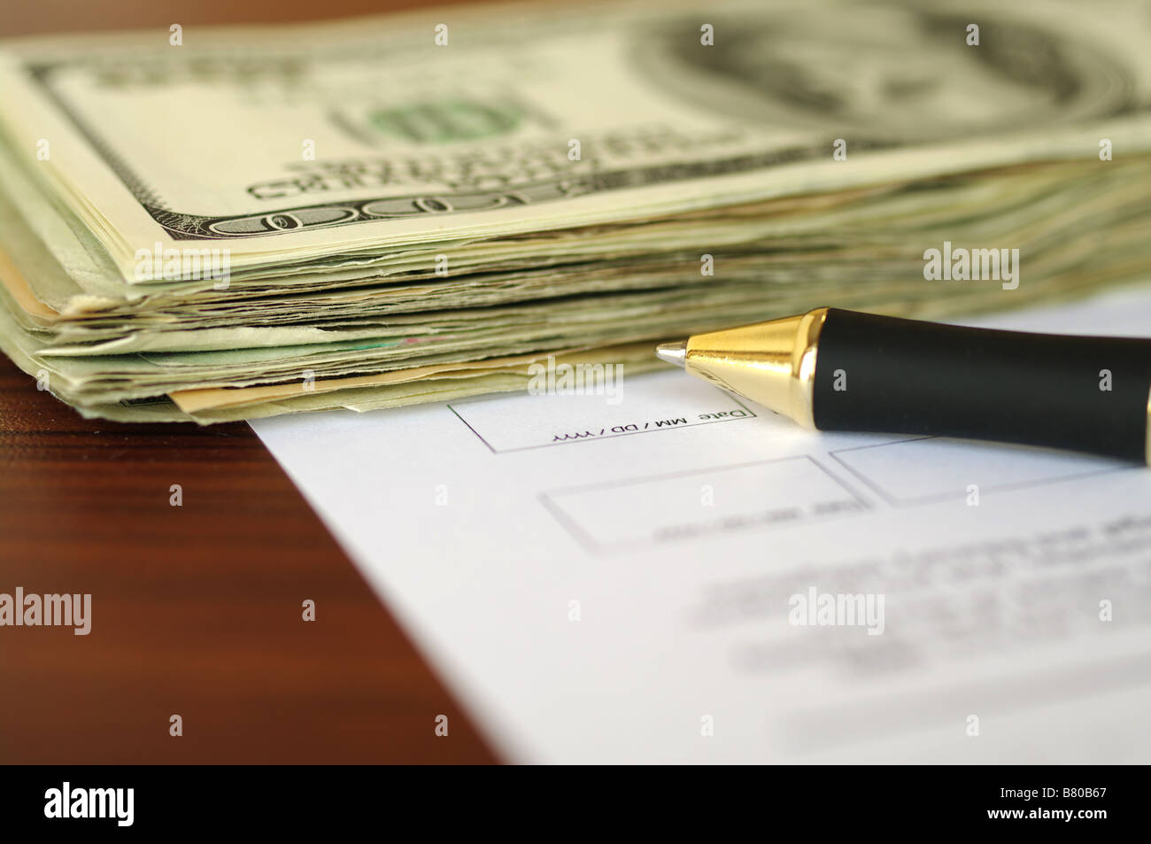 Stack of dollars and pen on a document page Stock Photo - Alamy
