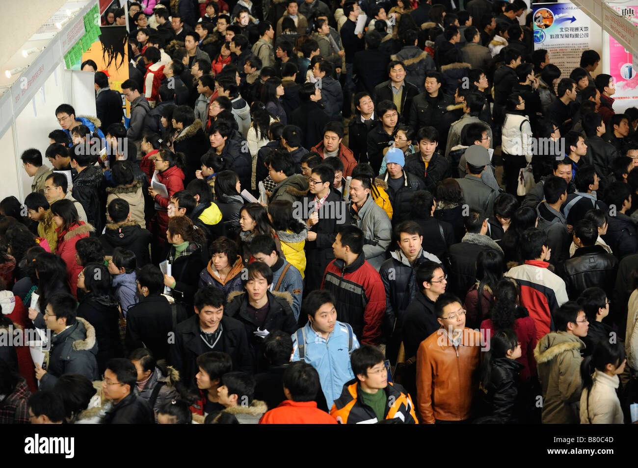 Job seekers crowd booths at a job fair in Beijing on February 8, 2009 ...