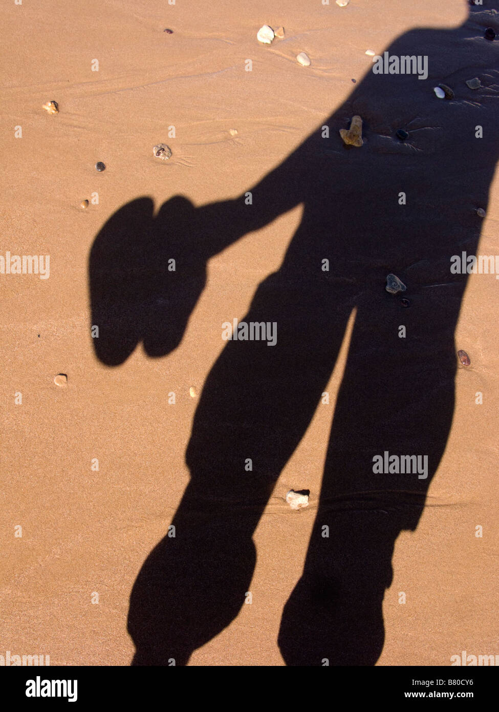 Shadow of person on beach sand Stock Photo - Alamy