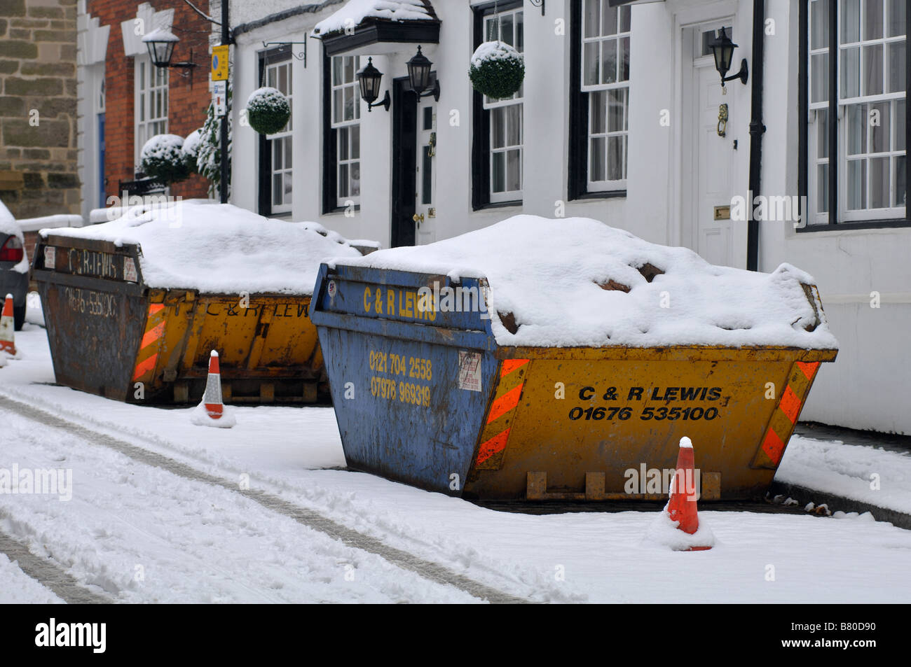 Full skips covered in snow, UK Stock Photo - Alamy