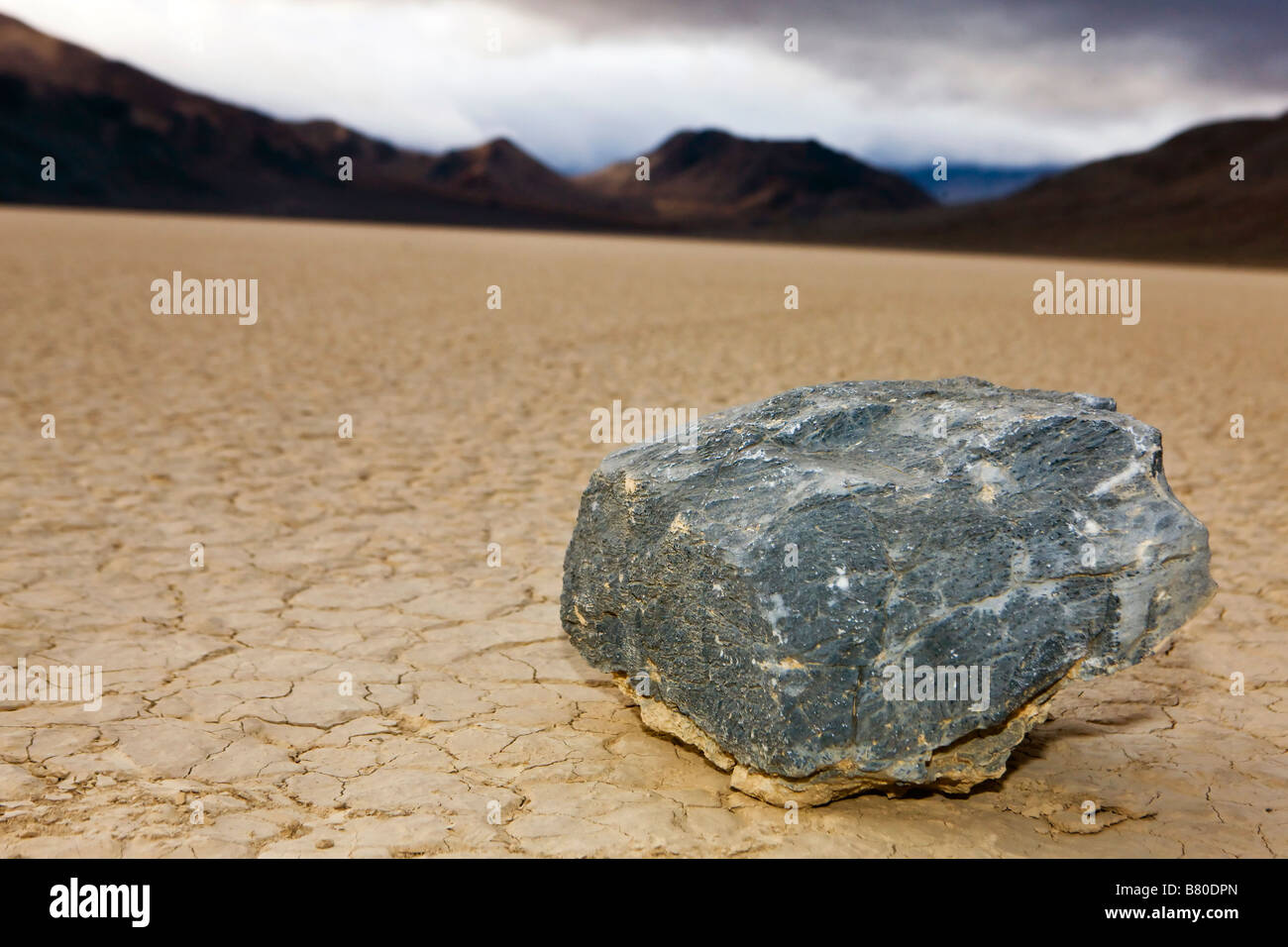 A mysterious moving rock slides with trail slides across the cracked ...