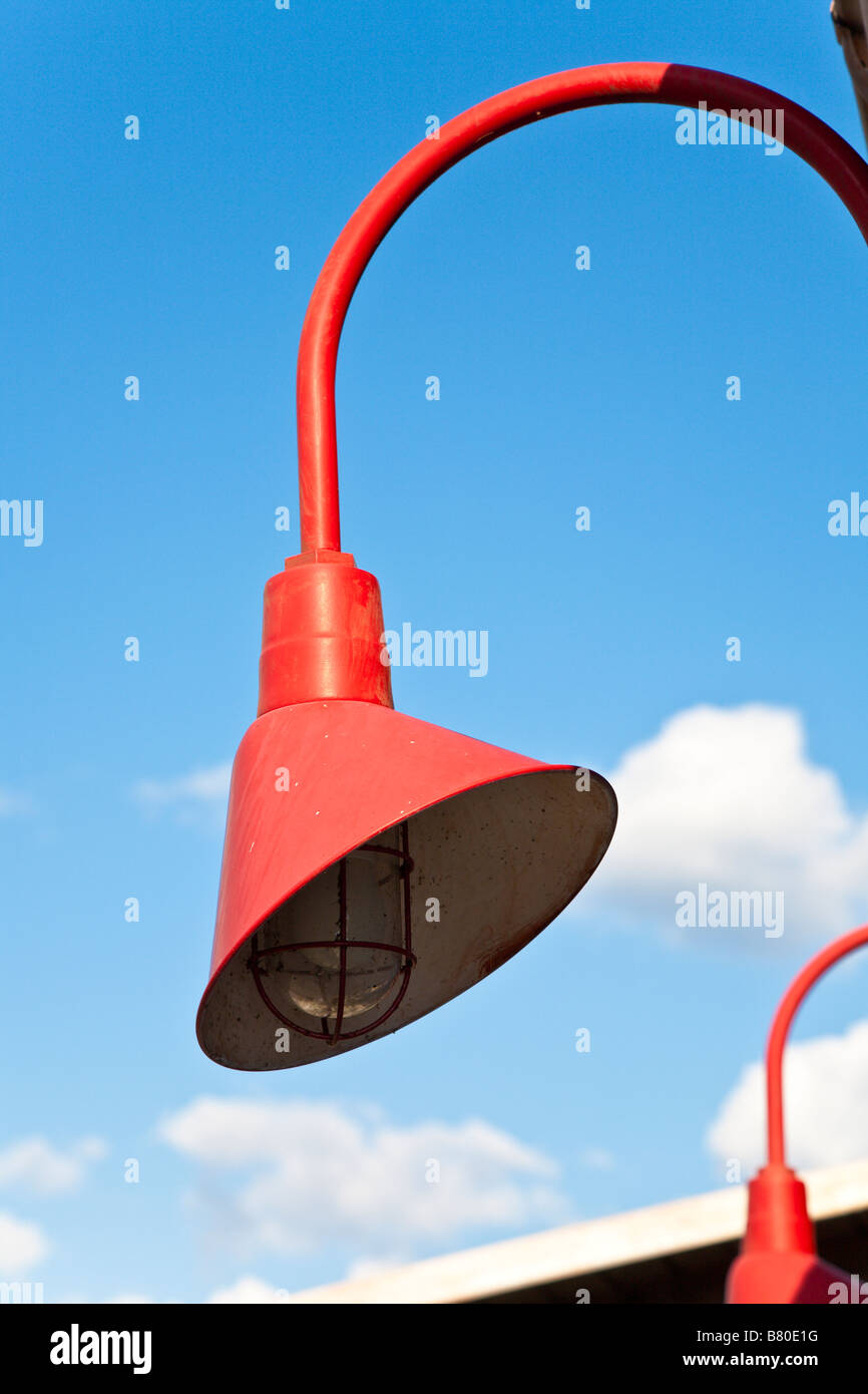 Bright red antique style lamp post against a bright blue sky with white ...
