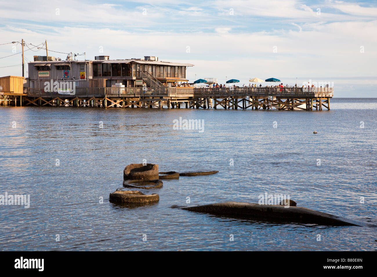 Old wooden restaurant and bar with seating outside overlooking the Gulf ...