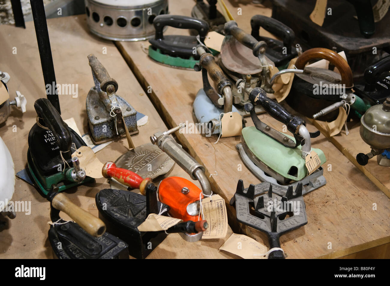 Collection of gas powered irons on a table/bench in a museum Stock ...