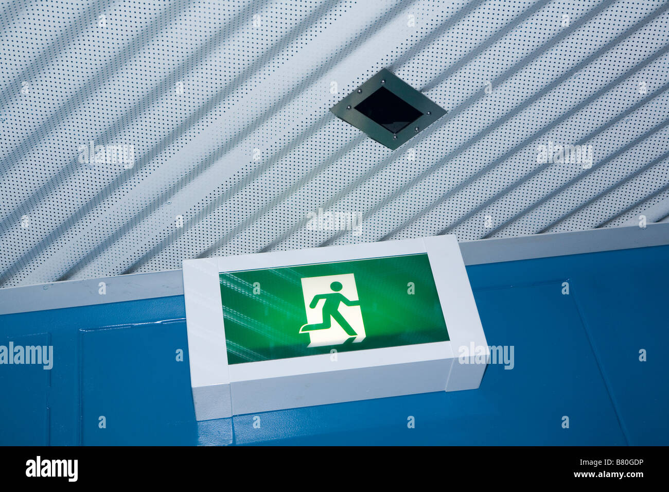 Emergency exit sign and security camera Stock Photo - Alamy