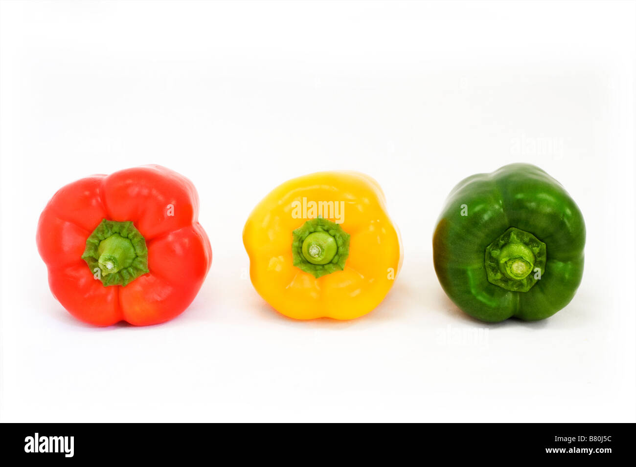 Three bell peppers in a row on a white background Stock Photo - Alamy