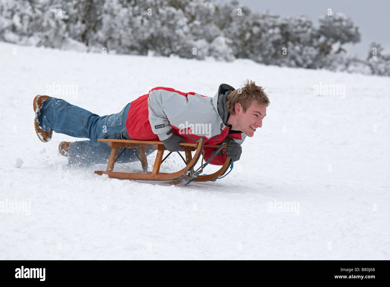 Man sledging in deep snow Cleeve Hill Cotswolds UK Stock Photo - Alamy