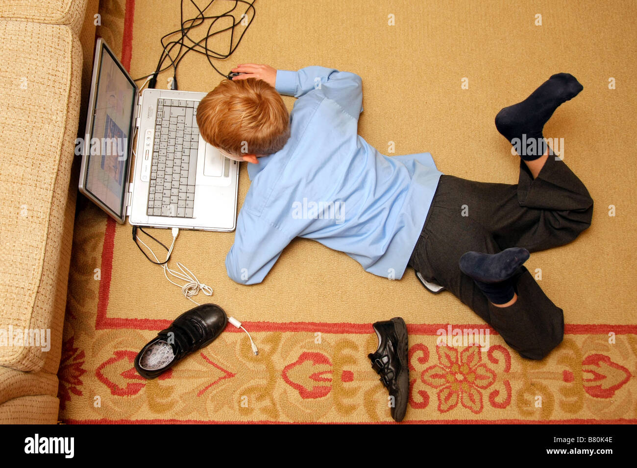 schoolboy home from school shoes off onto computer Stock Photo - Alamy
