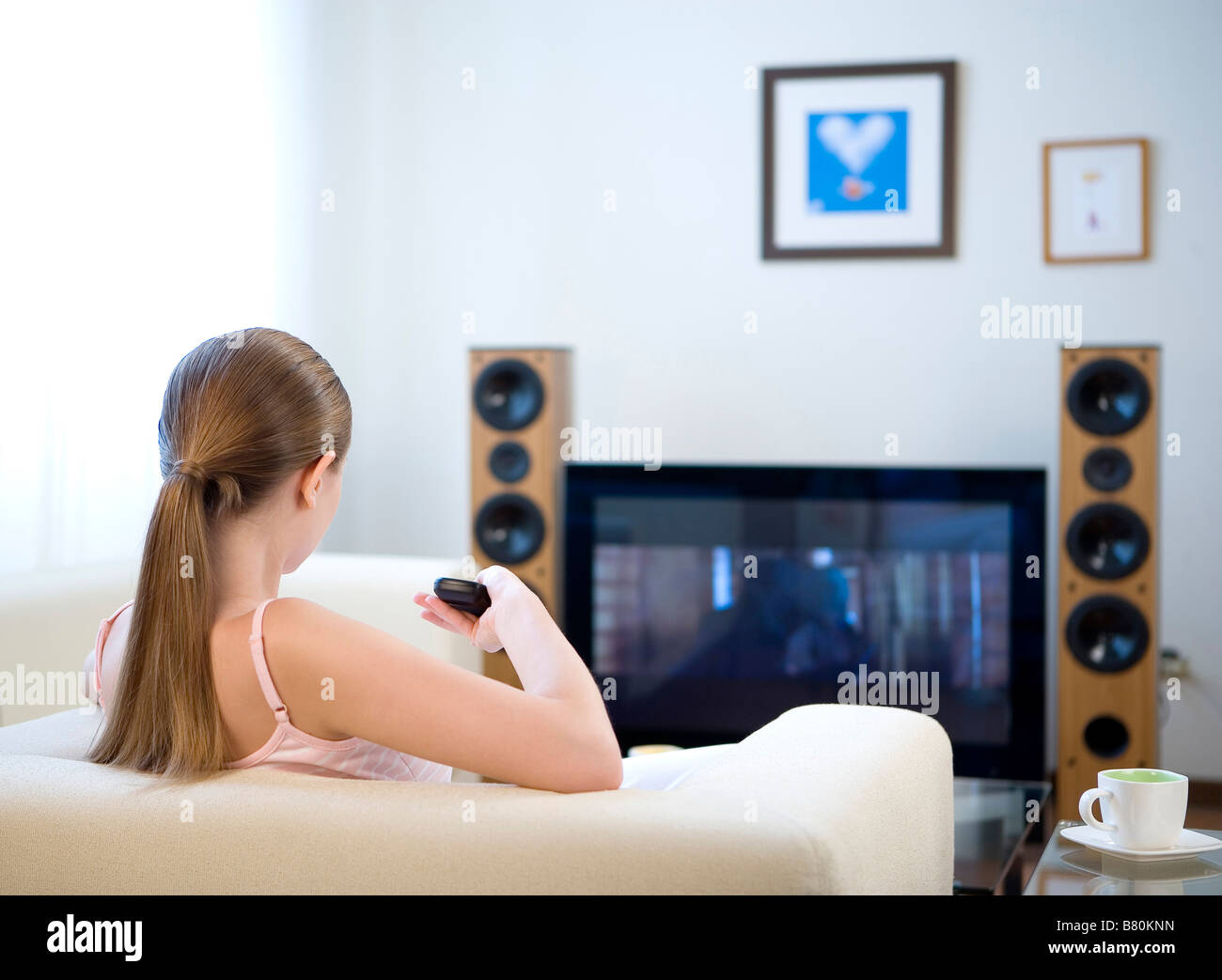 Young woman watching television on sofa rear view Stock Photo - Alamy