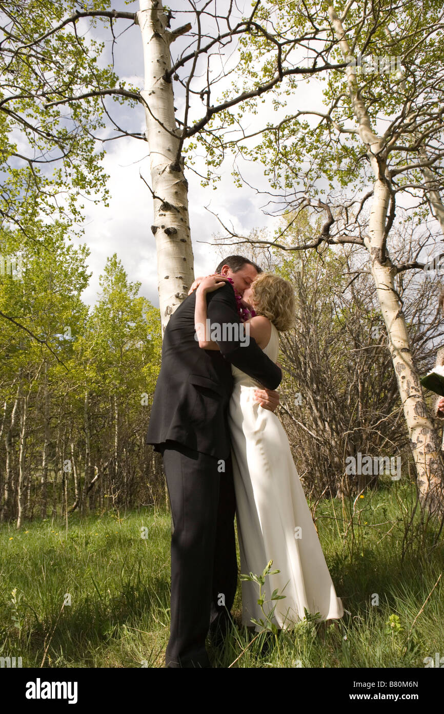 bride and groom embracing after wedding ceremony in a colorado forest ...