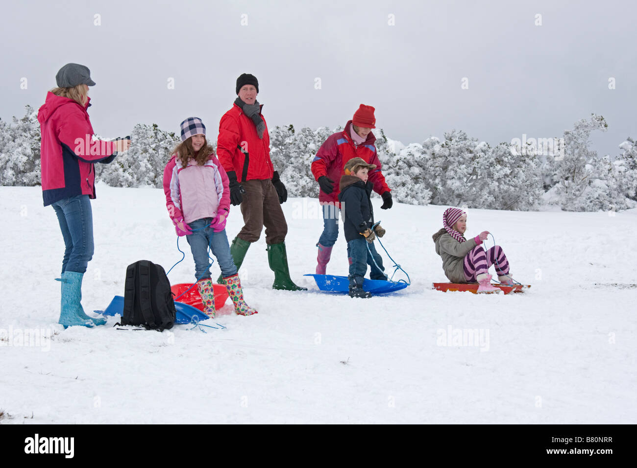 Family enjoying sledging in deep snow Cleeve Hill Cotswolds UK Stock ...