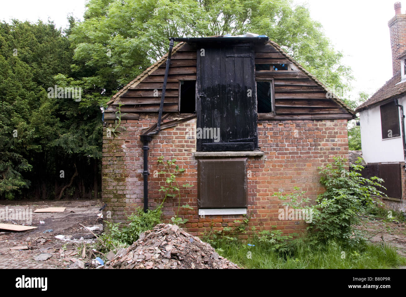 A run down old barn with trees in the background Stock Photo - Alamy