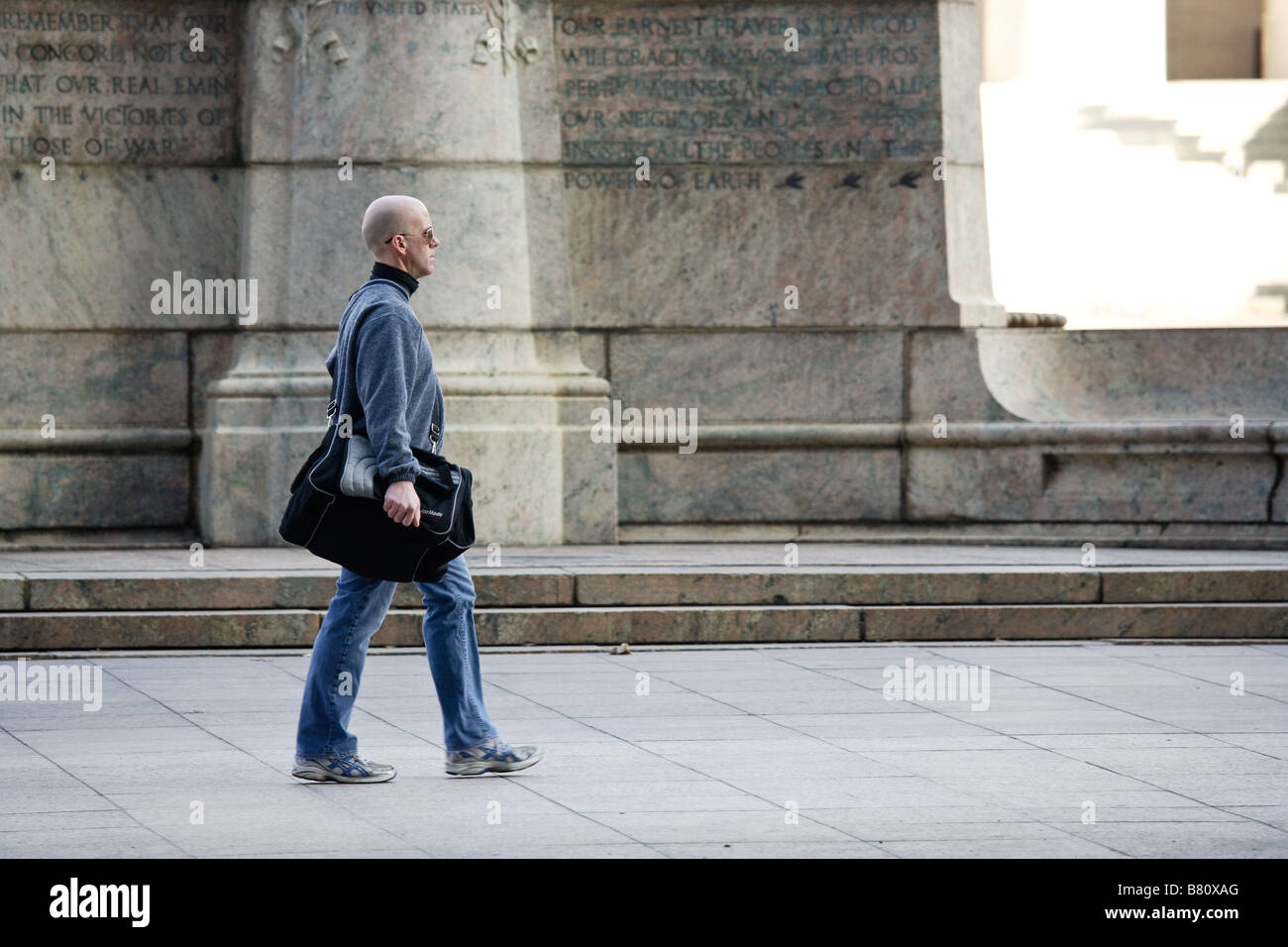A man walking along a sidewalk Stock Photo - Alamy