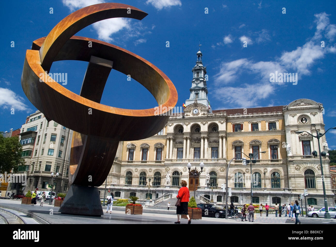 People going for a walk next to statue located to the side of the ...