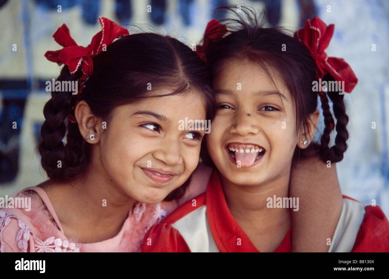 Two cheeky Indian girls having fun sticking out their tongues Stock ...