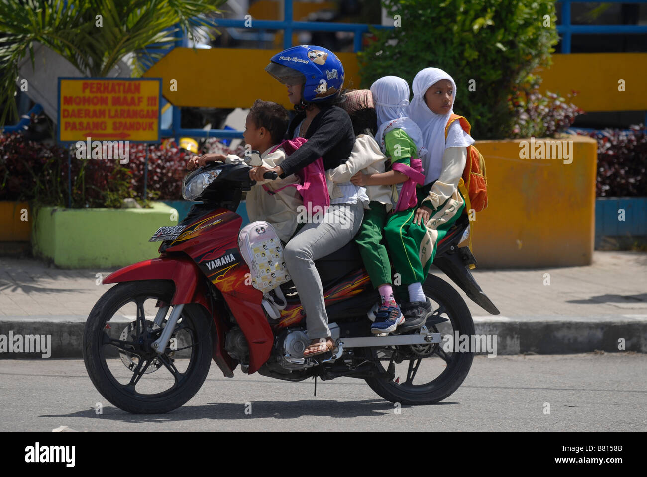 Motorcycle with a woman wearing a helmet and four children without ...
