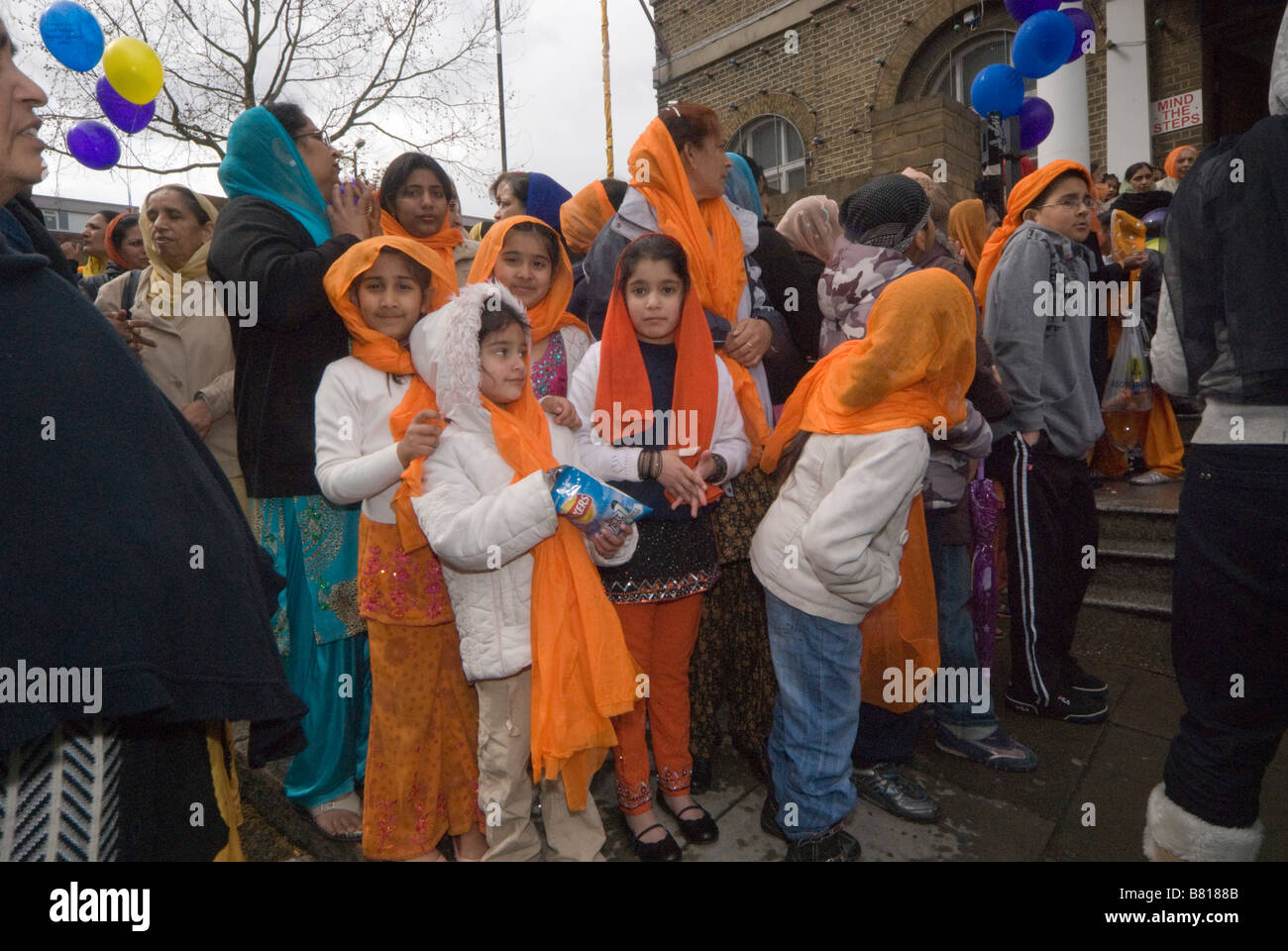A crowd of SIkh women and children wait outside the Gurdwara at the ...