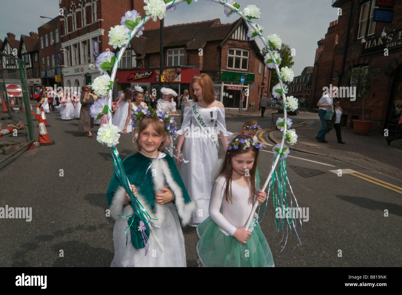 Two girls carry a floral arch in the May Queen procession through the ...