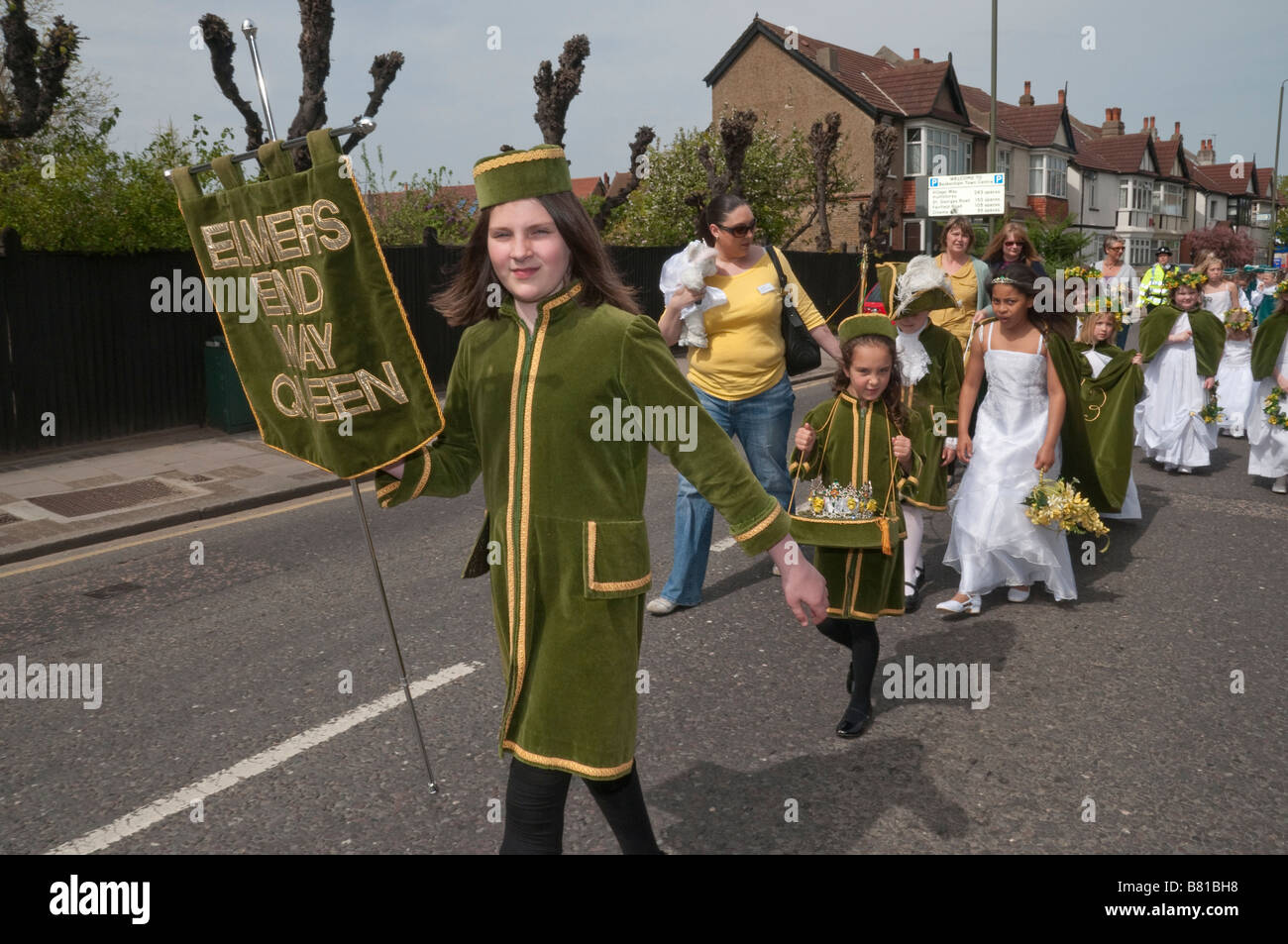 The Elmers End May Queen realm in procession on a suburban street in ...