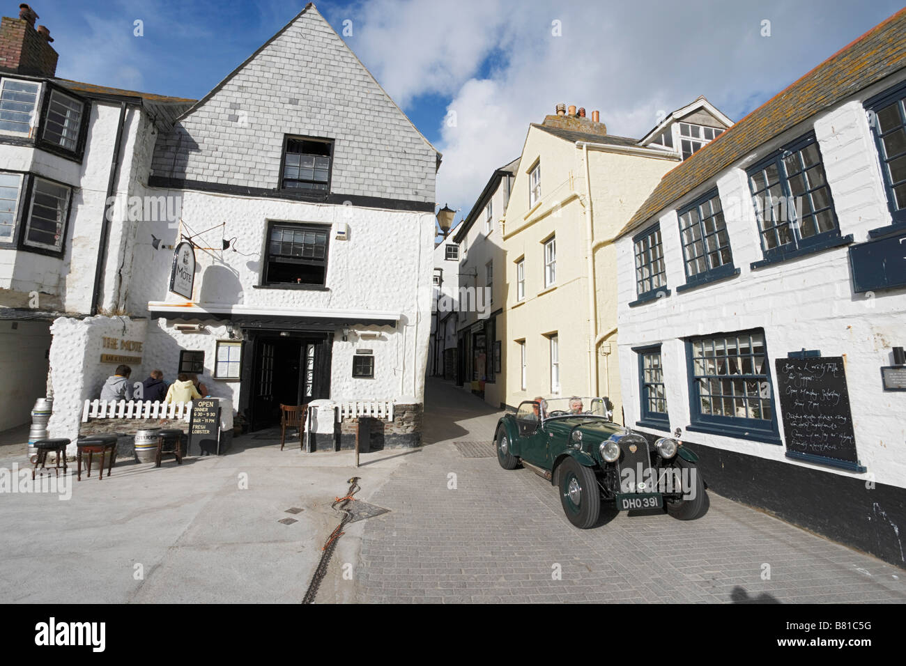 Vintage car passing a pub Port Isaac Cornwall England United Kingdom ...