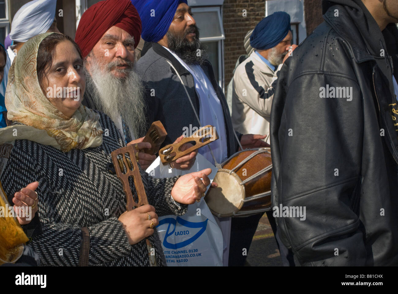 Sikh men and women with musical instruments in the Vaisakhi procession ...