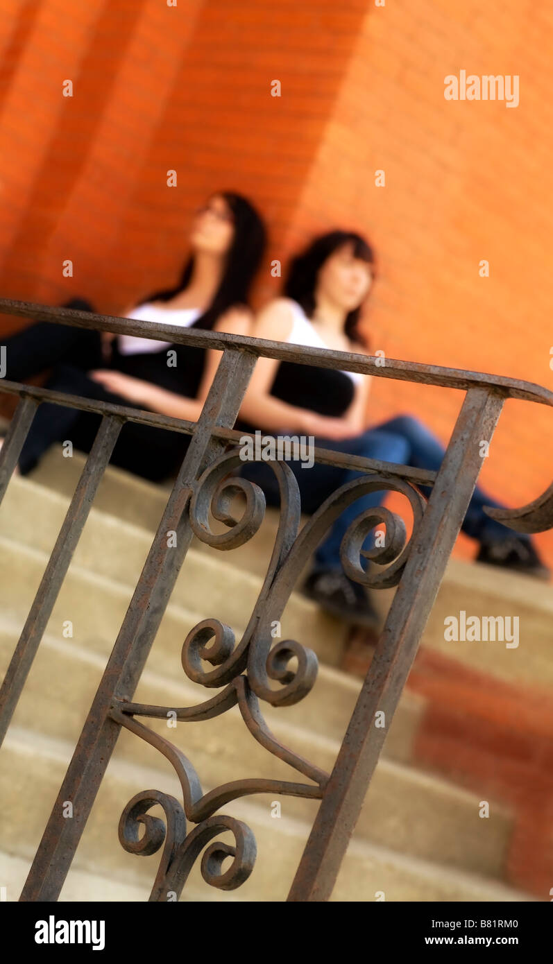 Two women sitting on stairs Stock Photo - Alamy