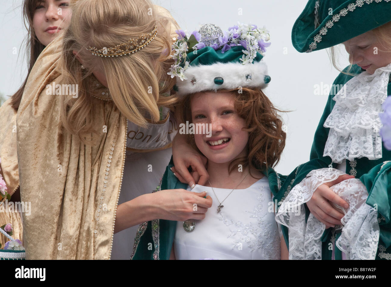 The 2008 London May Queen pins a badge onto a Realm Queen after ...