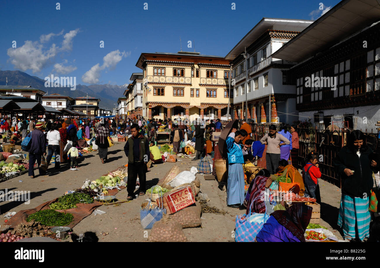 A crowd of people inspect goods on sale in the market square in Paro ...
