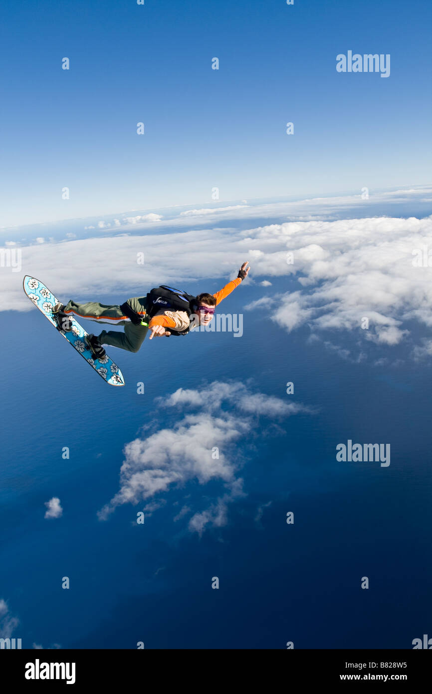 Skydiver is surfing the big blue sky over clouds into the deep blue sea ...