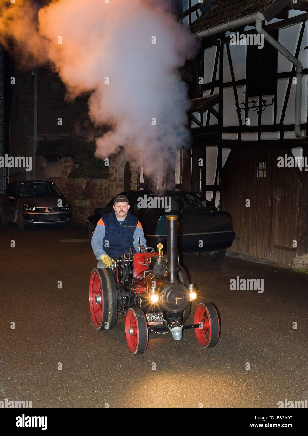 MAN DRIVING A SCALE MODEL STEAM TRACTION ENGINE AT NIGHT ALSACE FRANCE ...