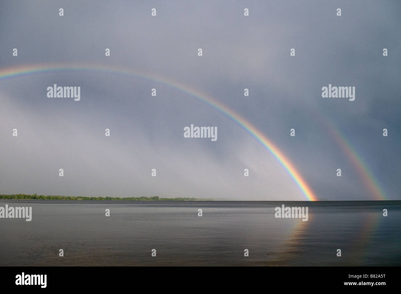 Rainbow breaks through rain storm at sunset Big Pine Lake Minnesota ...