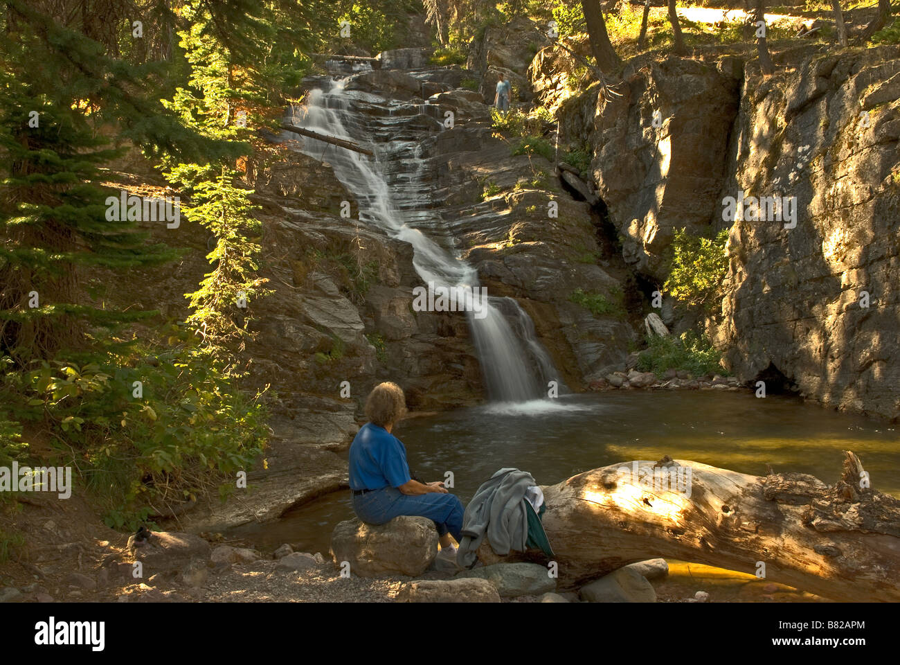 Female watching a waterfall Stock Photo - Alamy