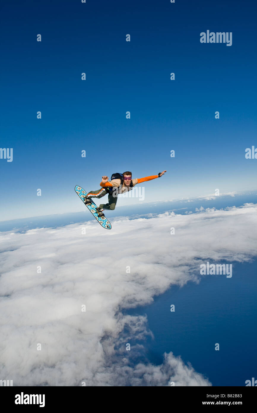 Skydiver is surfing the big blue sky over clouds into the deep blue sea ...