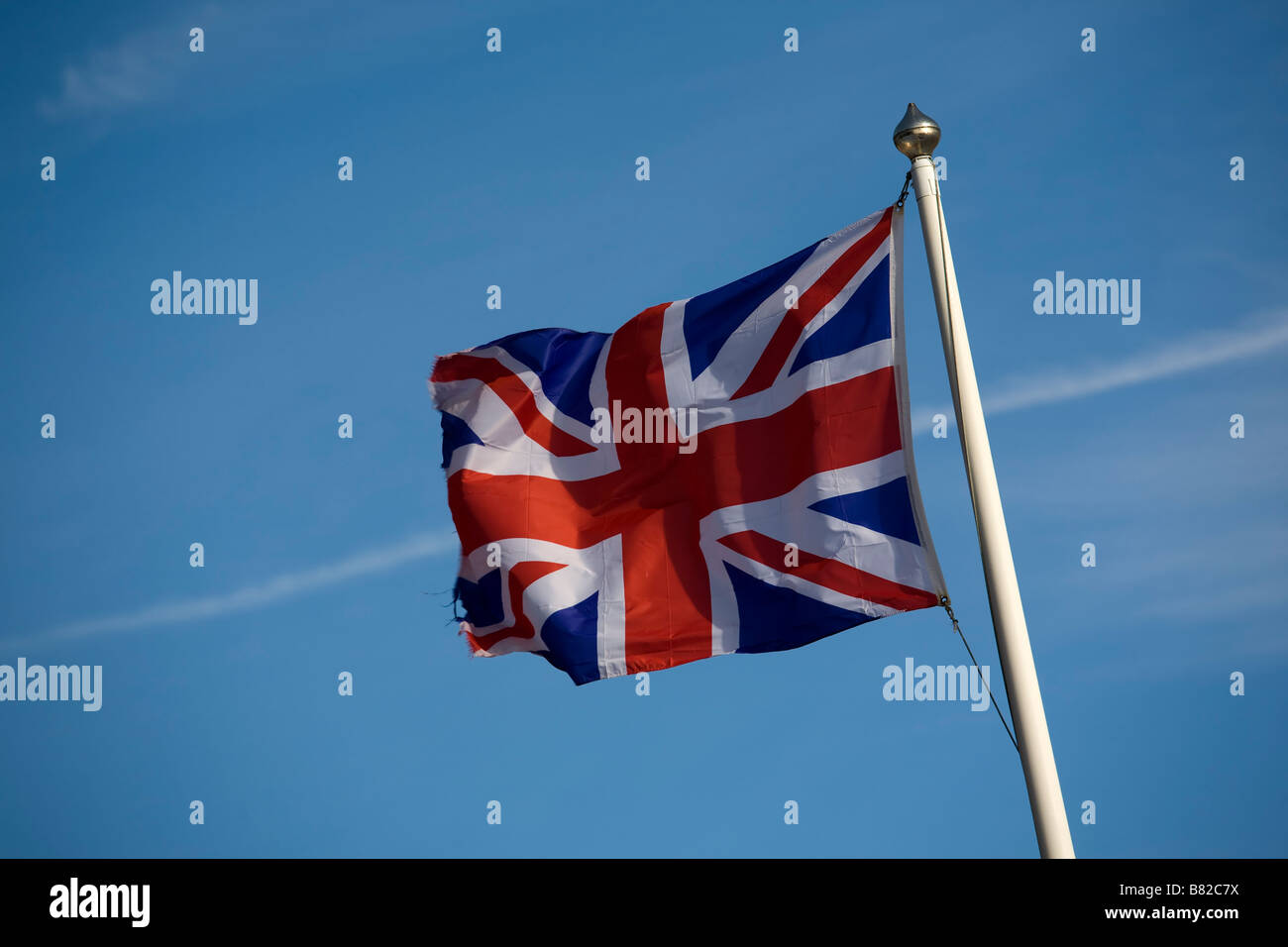 Union Jack flag flying on flagpole against blue sky Stock Photo - Alamy