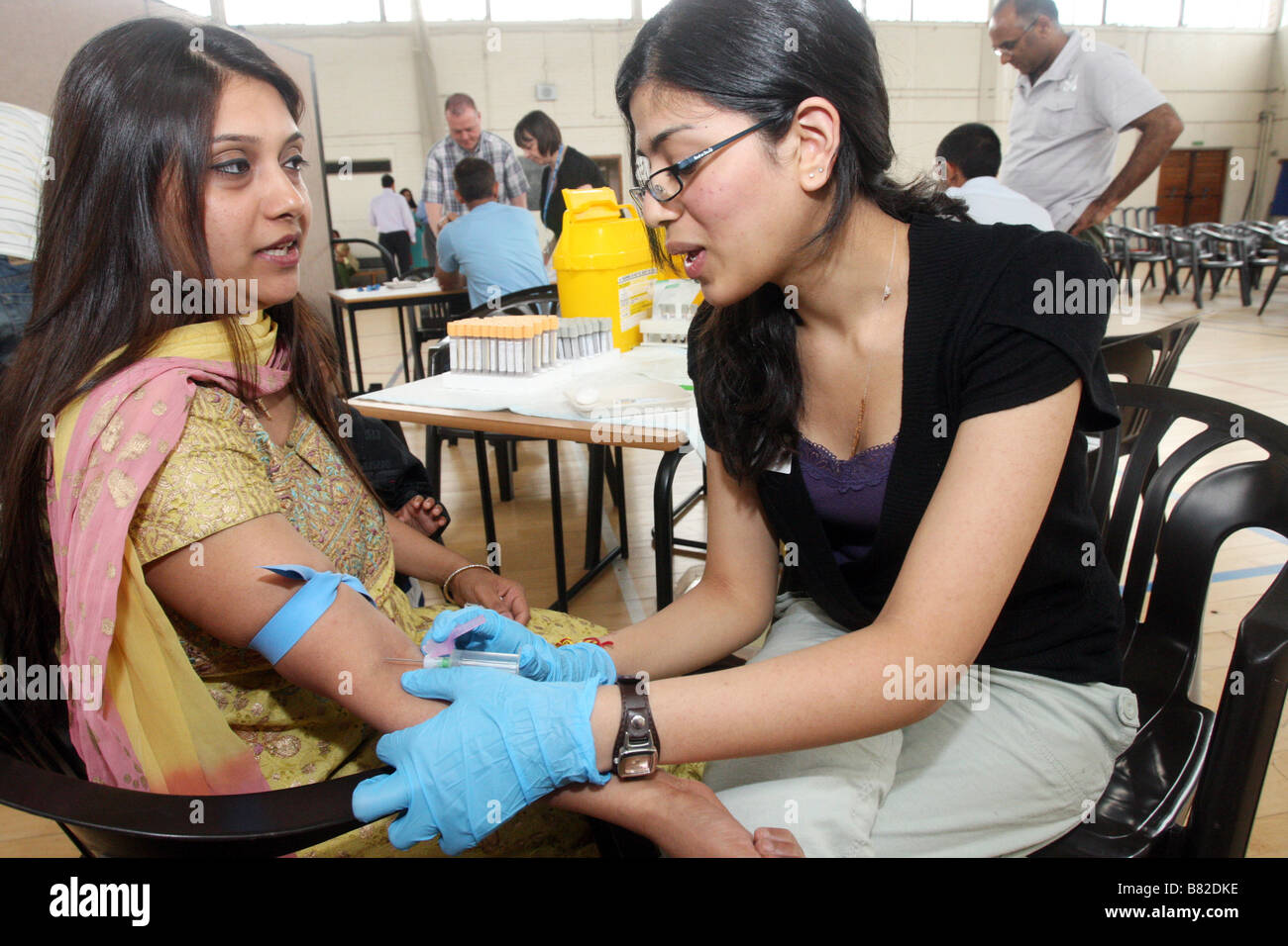 A woman taking a blood sample from another woman's arm Stock Photo - Alamy