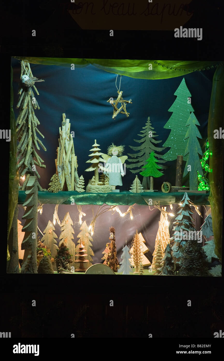 ILLUMINATED CHRISTMAS WINDOW DECORATED WITH MODEL WOODEN TREES DURING ...