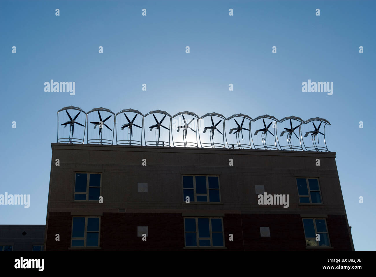 Wind turbines are seen on the roof of an apartment building under ...