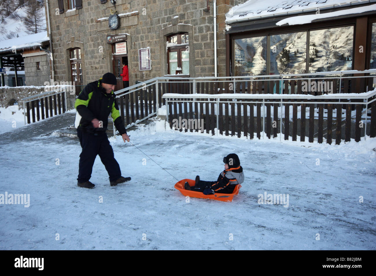 Kid being carried by his father on a sled Stock Photo - Alamy