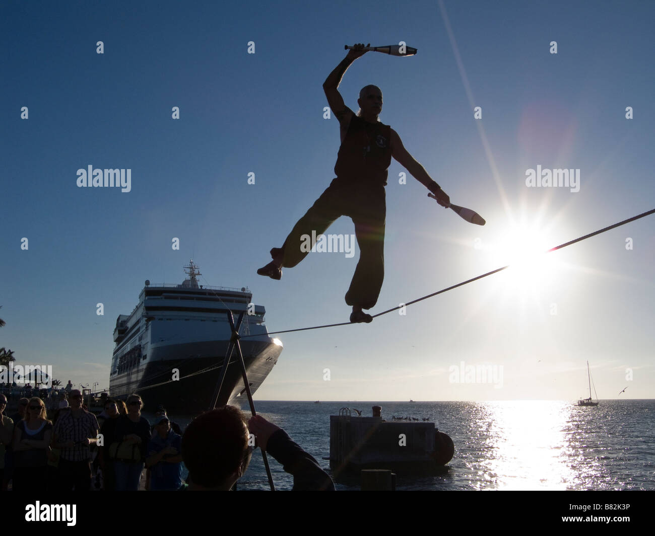 Tight rope walker juggles over ocean at sunset Mallory Square Key West ...