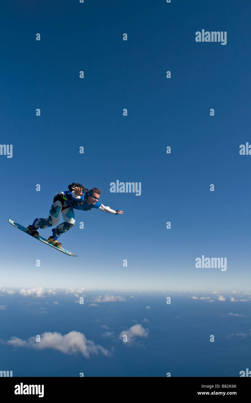 Skydiver is surfing the big blue sky over clouds into the deep blue sea ...