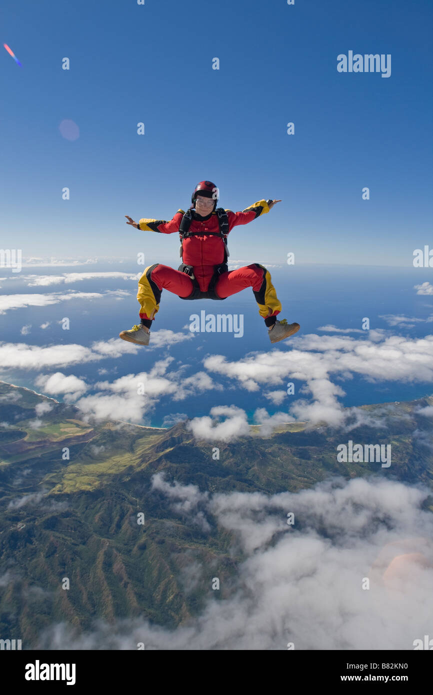 Skydiver is sit flying in the blue sky over a big cloud and having fun ...
