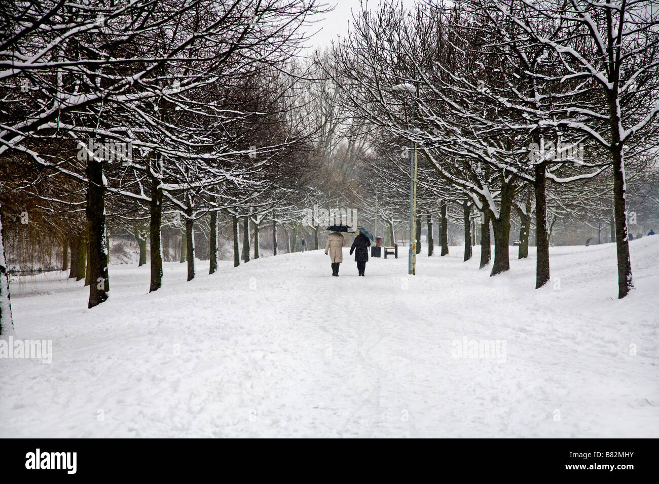 Two people walking in the Snow Stock Photo - Alamy
