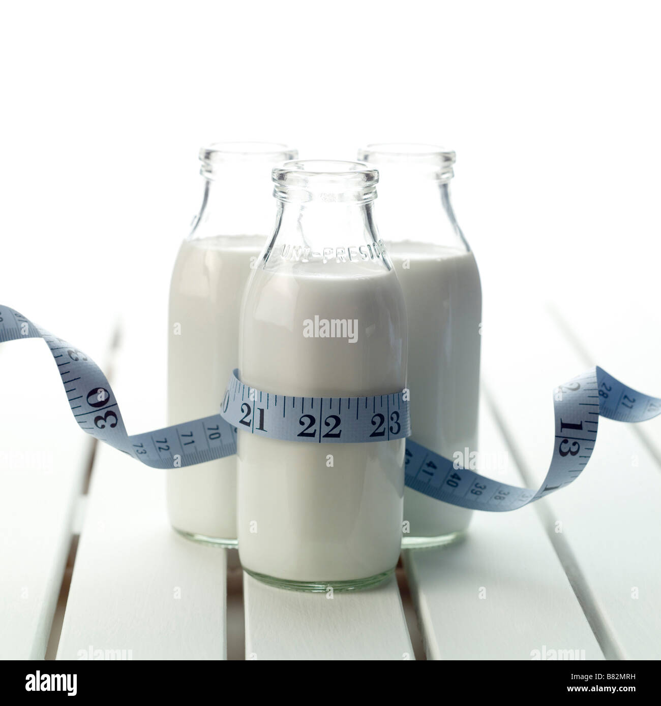 Tape measure around bottle of milk Stock Photo - Alamy