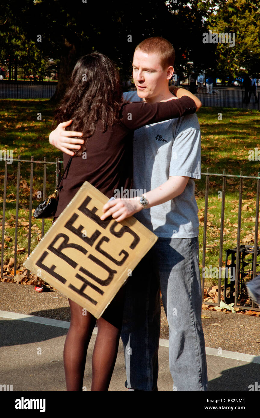 A man carrying a Free Hugs sign hugging a girl at speakers corner Stock ...
