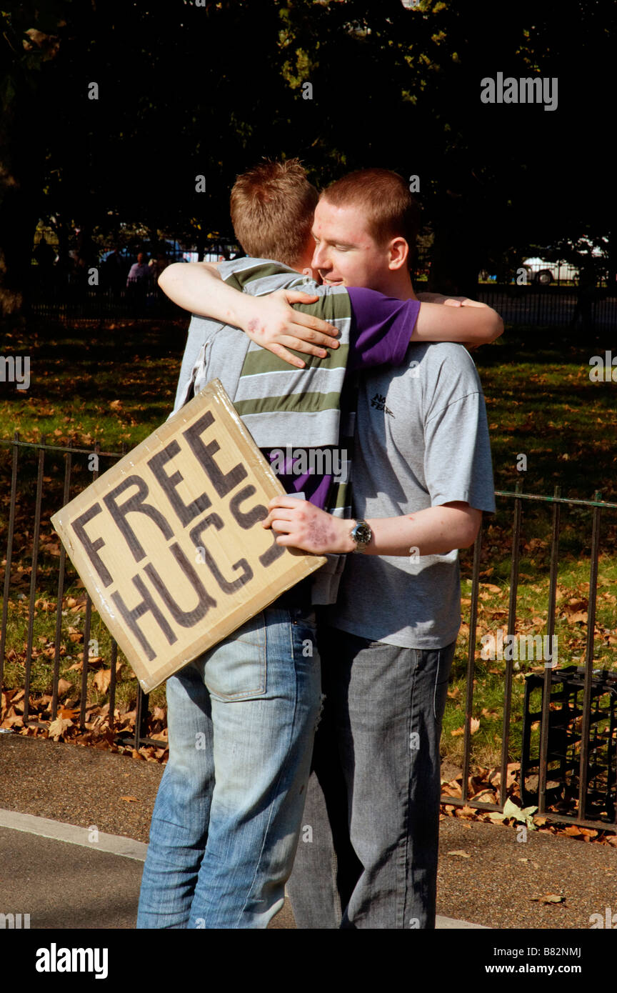 A man carrying a Free Hugs sign hugging a a man at speakers corner ...