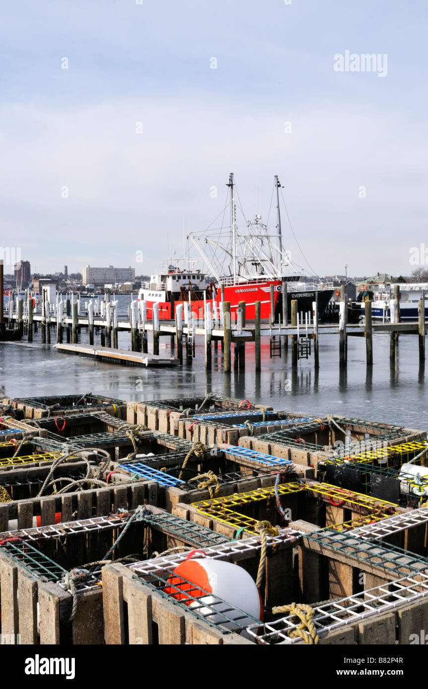 New England winter harbor with commercial fishing boats & ice on docks ...