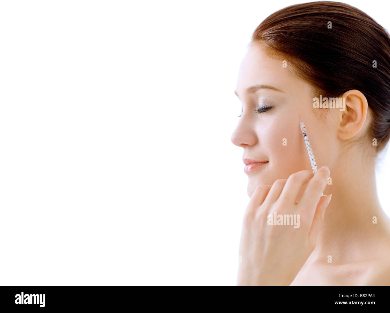 Portrait of young woman holding syringe near face smiling side view ...