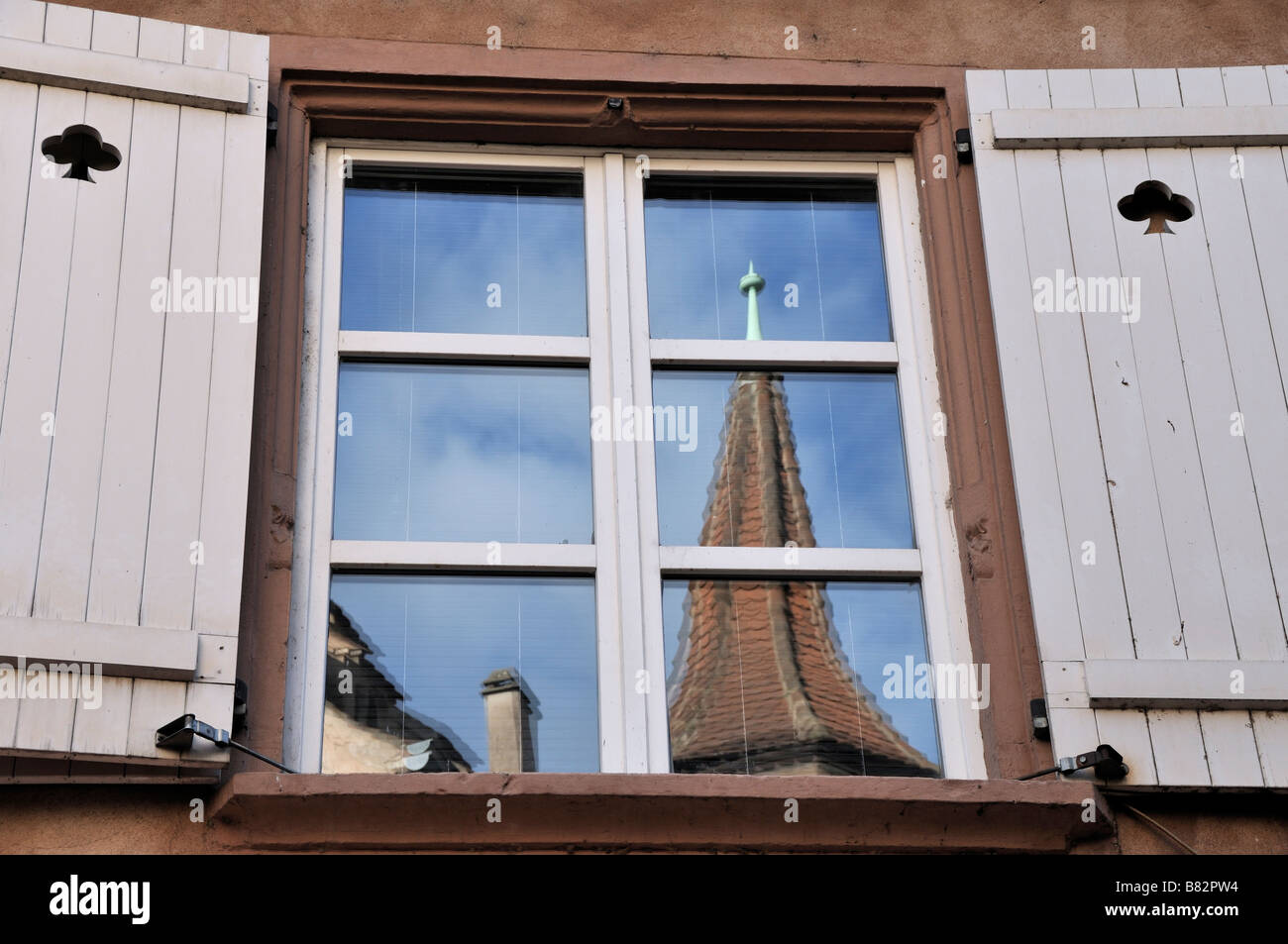 Reflection of a church steeple in a window with open shutters Stock ...